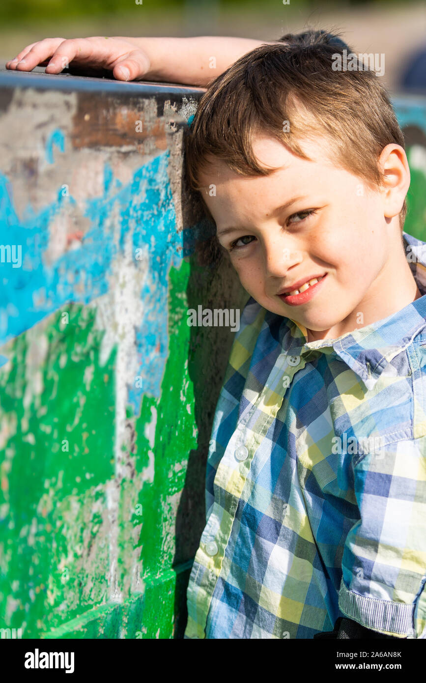 A little boy with ADHD, Autism, Asperger syndrome stands by a wall to ...