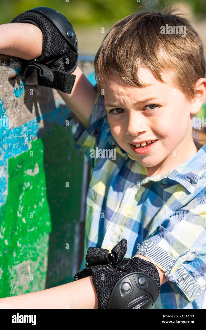 A little boy with ADHD, Autism, Asperger syndrome stands by a wall to ...