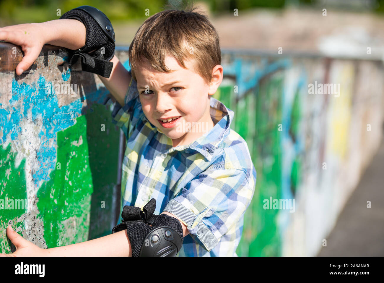 A little boy with ADHD, Autism, Asperger syndrome stands by a wall to ...