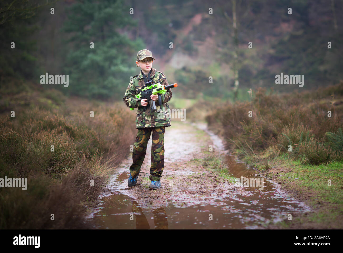 A little boy with ADHD, Autism poses in camouflage (DPMs) with his BB ...