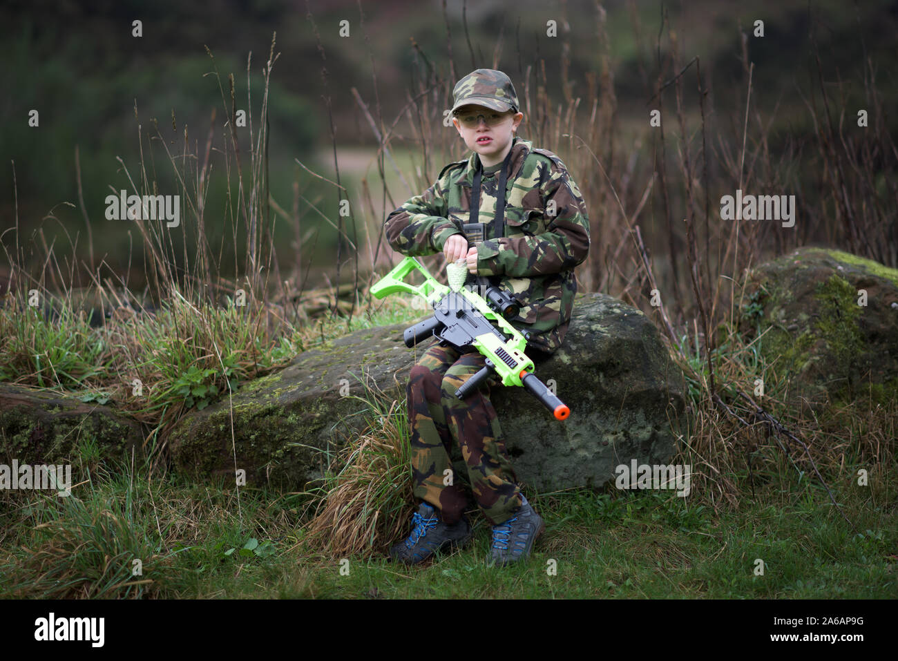 A little boy with ADHD, Autism poses in camouflage (DPMs) with his BB ...