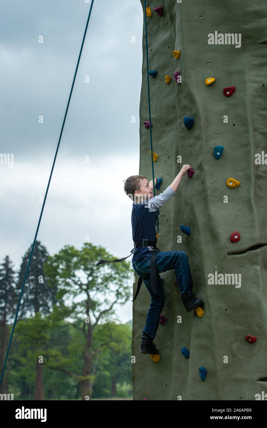 People try their hands at climbing on a huge mobile outdoor climbing ...