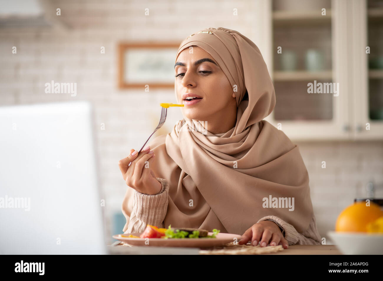 Muslim woman enjoying the taste of her dinner Stock Photo - Alamy