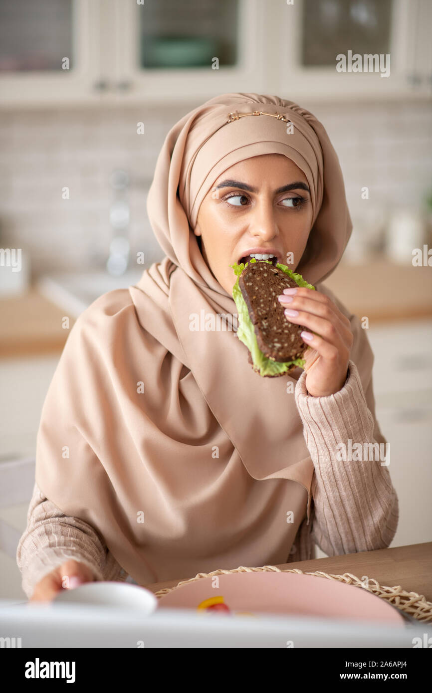Pretty woman eating a whole wheat bread sandwich Stock Photo - Alamy