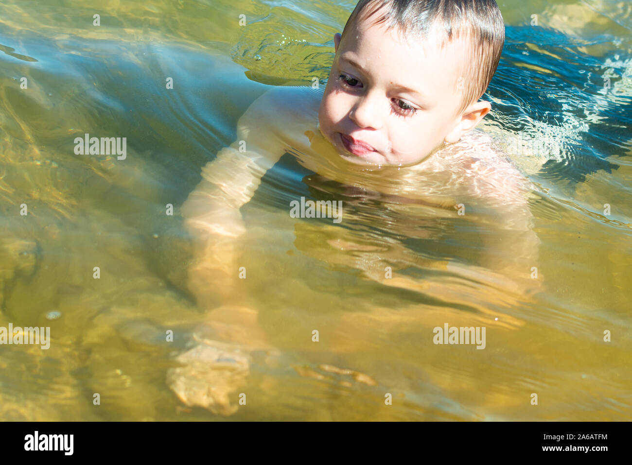 A Handsome Little Boy With ADHD Autism Asperger Syndrome Swimming Splashing Water In The Sea a-handsome-little-boy-with-adhd-autism-asperger-syndrome-swimming-splashing-water-in-the-sea