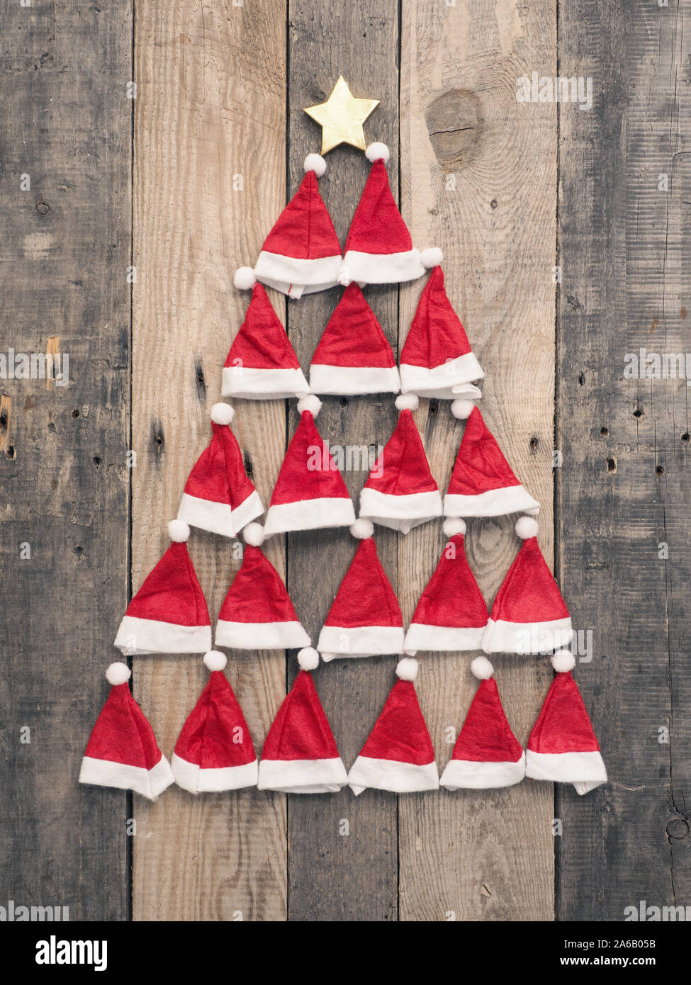 Abstract Christmas tree shape of many hats of Santa with a golden star ...