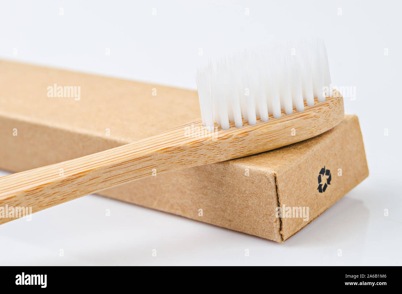 Bamboo toothbrushes on brown paper box with recycle sign on white ...