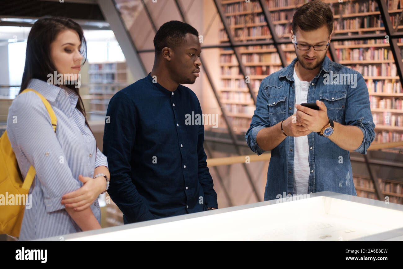 Multicultural group of students in a public library Stock Photo - Alamy