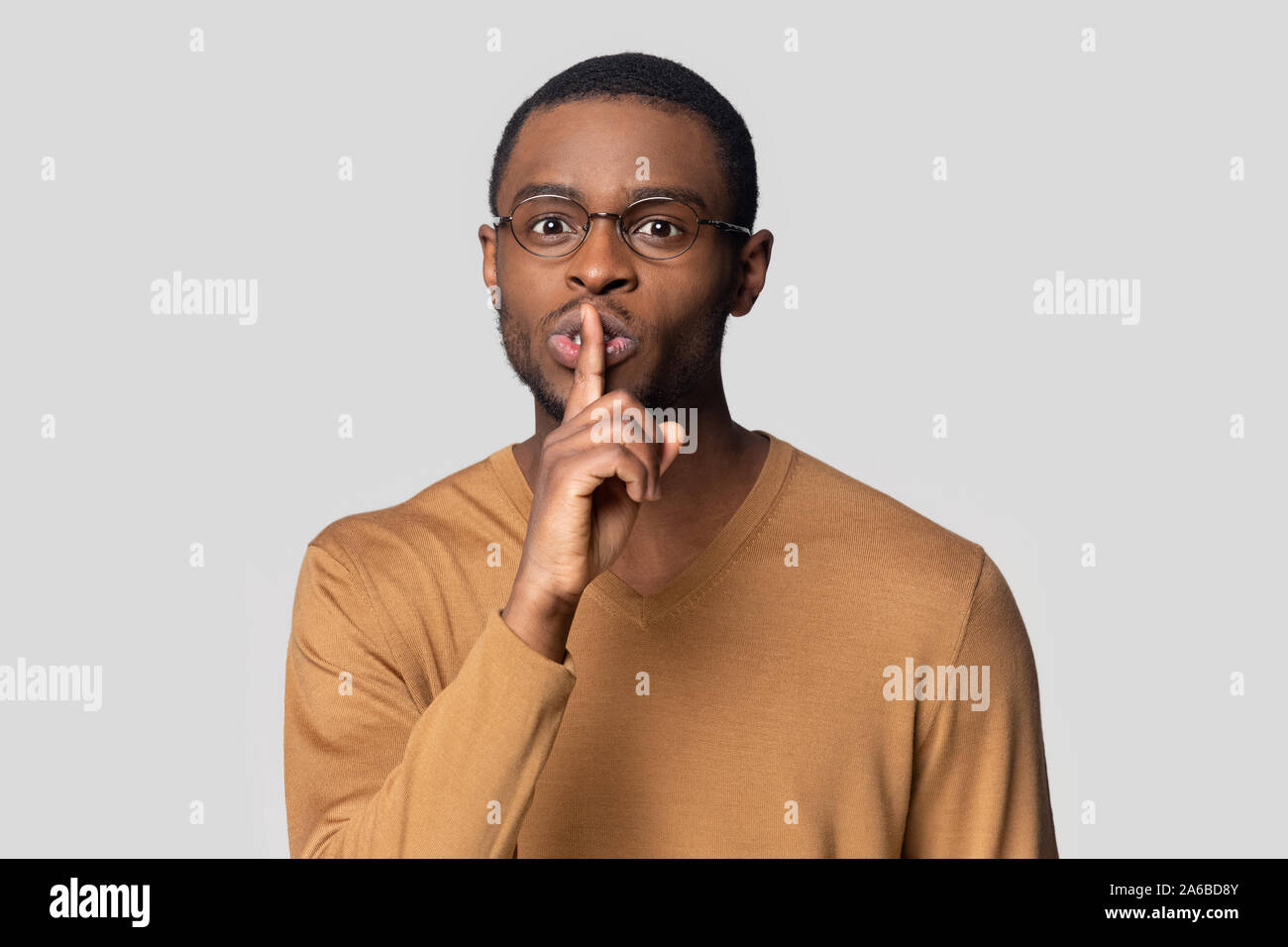 Head shot funny African American man showing hush gesture Stock Photo ...