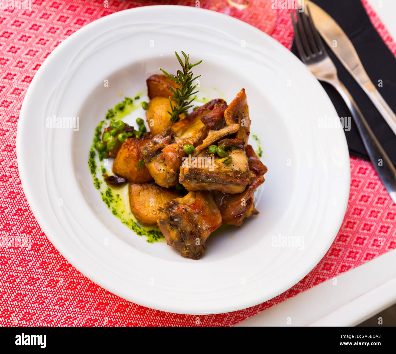 Delicious dish – rabbit meat with garlic served with peas and greens ...