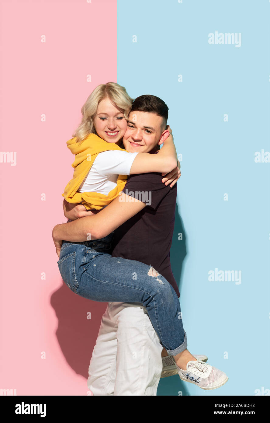 Young emotional man and woman in bright casual clothes posing on pink ...