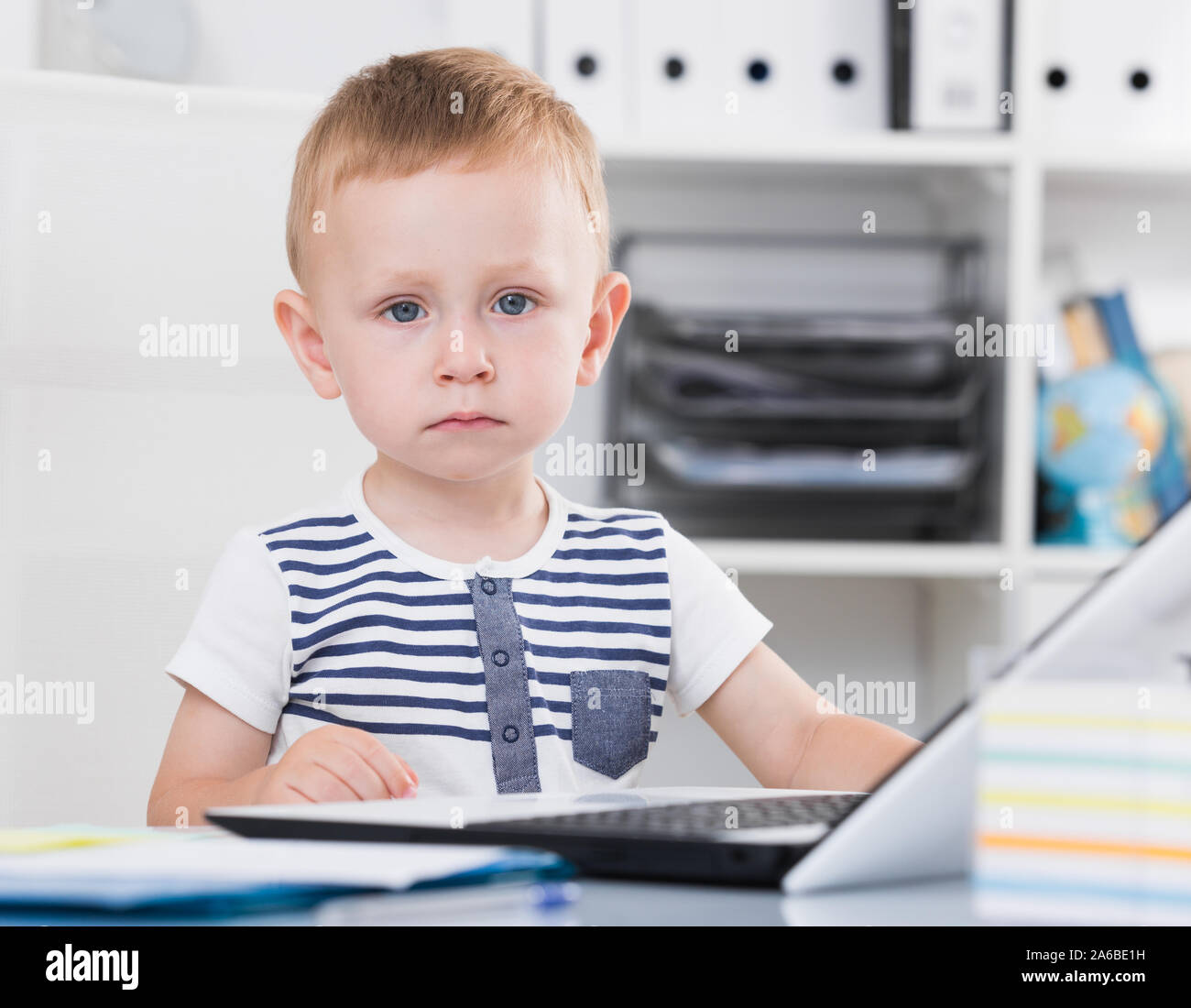 Cute kid is playing on laptop in the office Stock Photo - Alamy