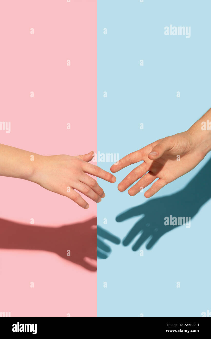 Female and male hands holding on pink and blue background. Concept of ...