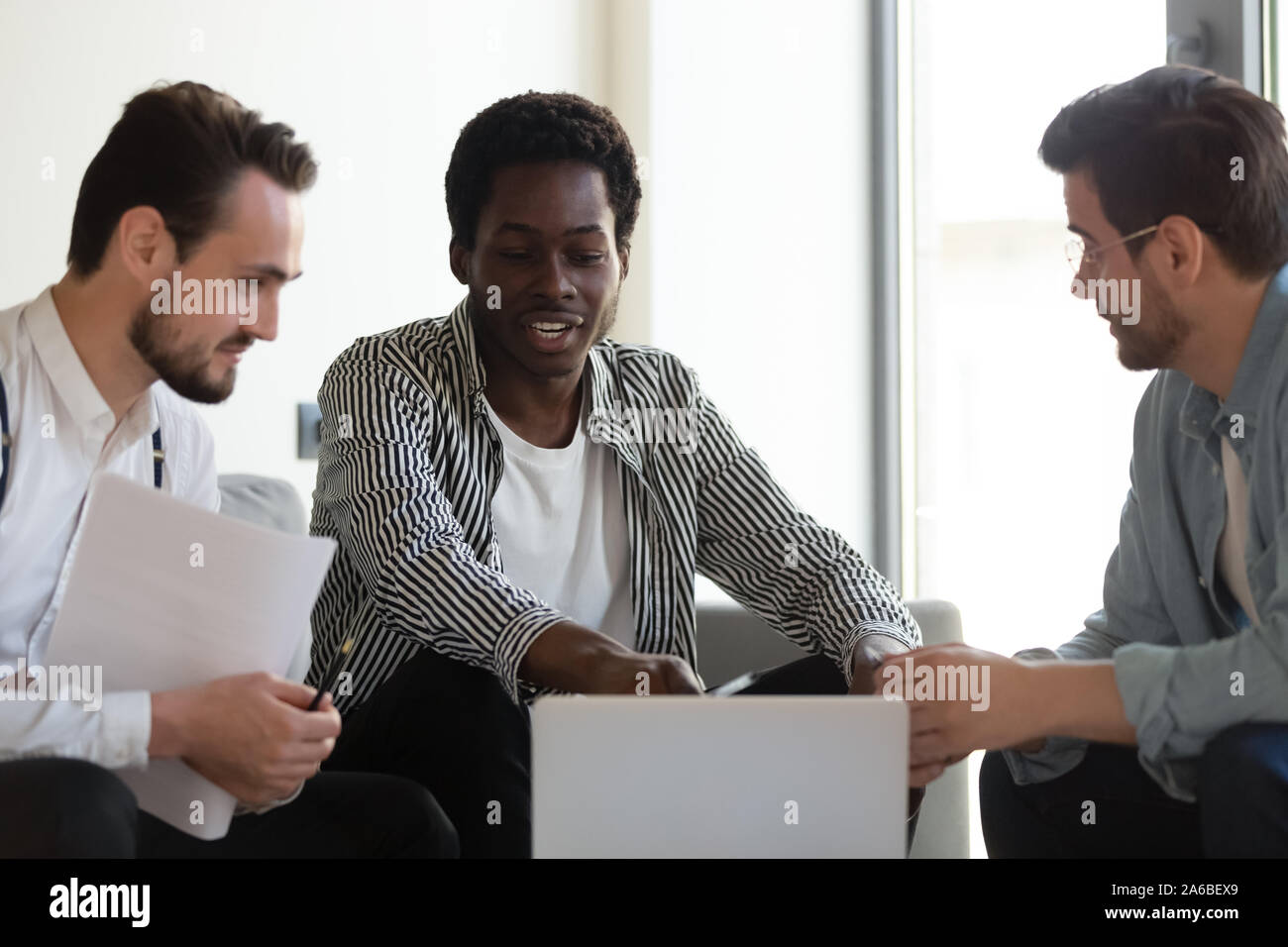 African American employee discussing project with colleagues Stock ...