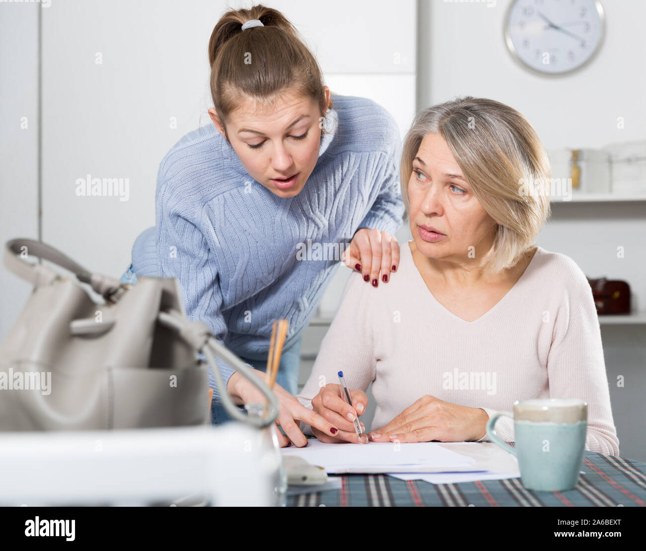 Woman and adult daughter fill out paperwork Stock Photo - Alamy