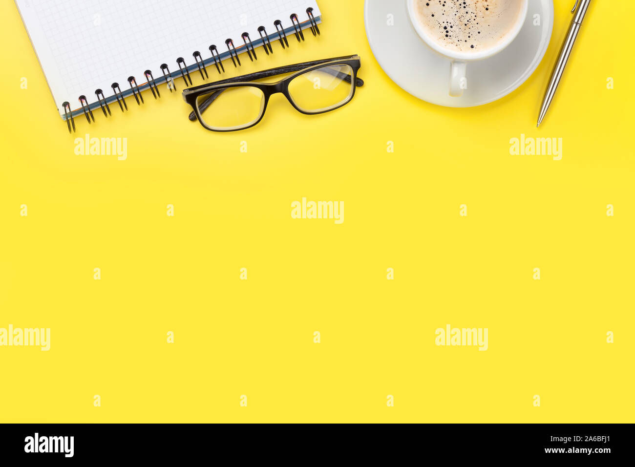 Office yellow workplace backdrop with coffee cup and supplies. Flat lay ...