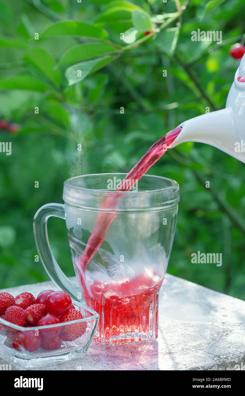 Hot berry tea poured in the garden Stock Photo - Alamy