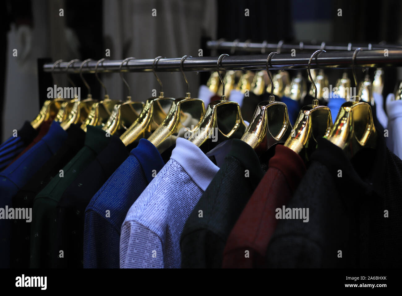 New clothes collection on the golden hangers in the store Stock Photo ...