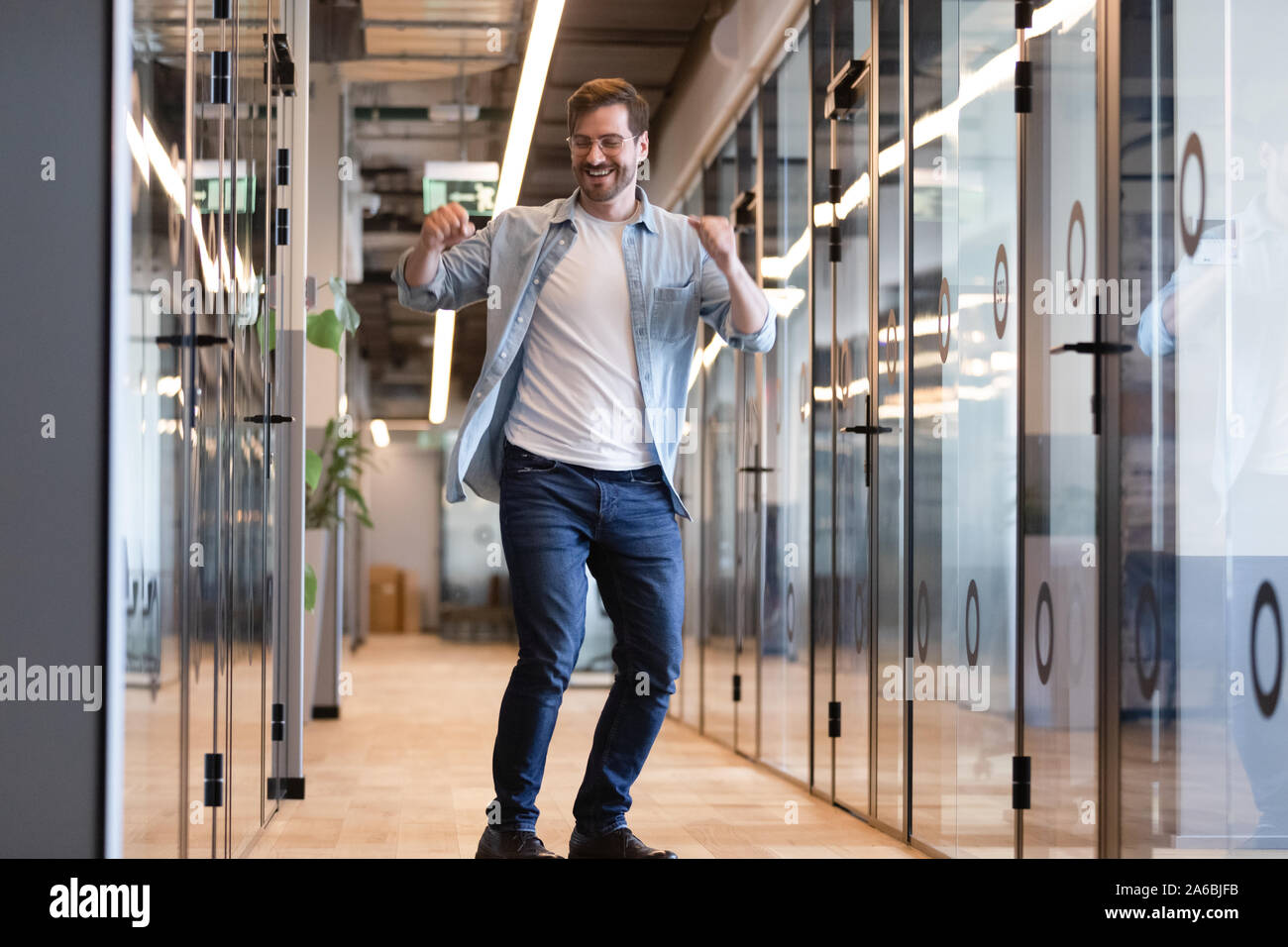 Happy businessman dancing in office hallway, celebrating success Stock ...