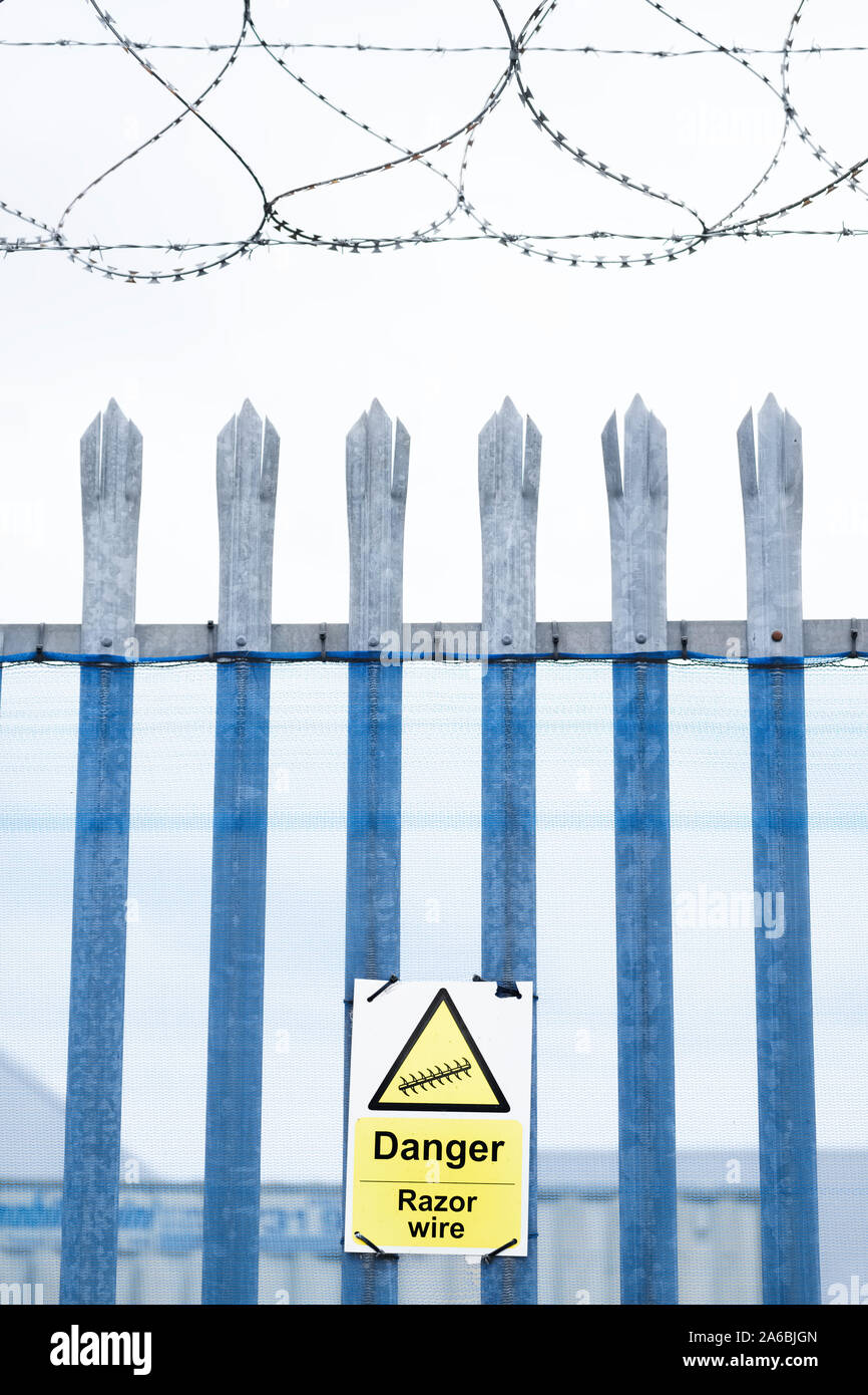 Razor wire danger sign on security fence Stock Photo - Alamy