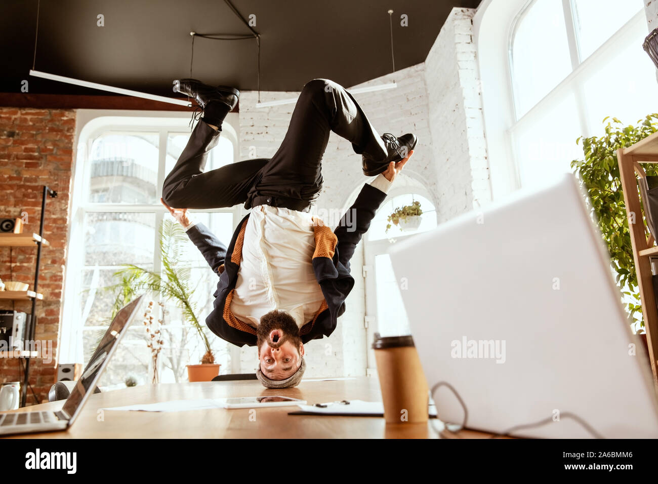 Young caucasian businessman having fun dancing break dance in the ...
