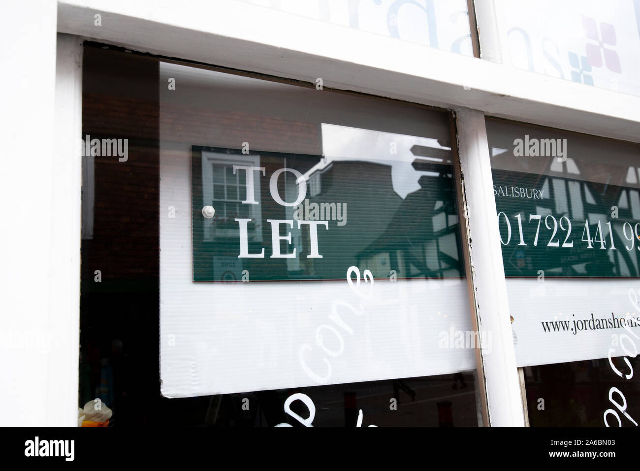 Retail unit to let estate agent advertising sign in vacant shop window ...