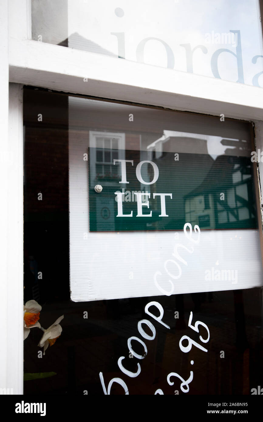 Retail unit to let estate agent advertising sign in vacant shop window ...