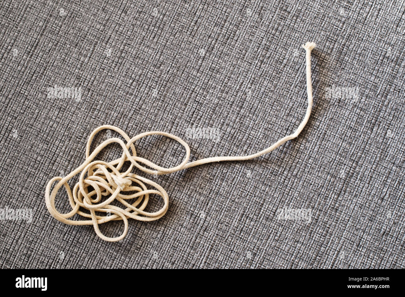 Tangled string on gray fabric Stock Photo - Alamy