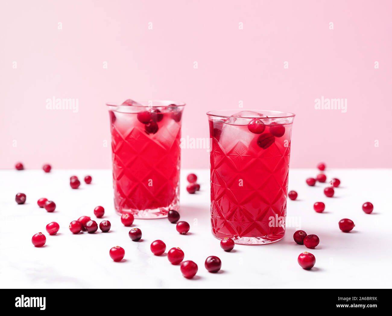 Cranberry cocktail in crystal glasses with ice decorated by berries on ...