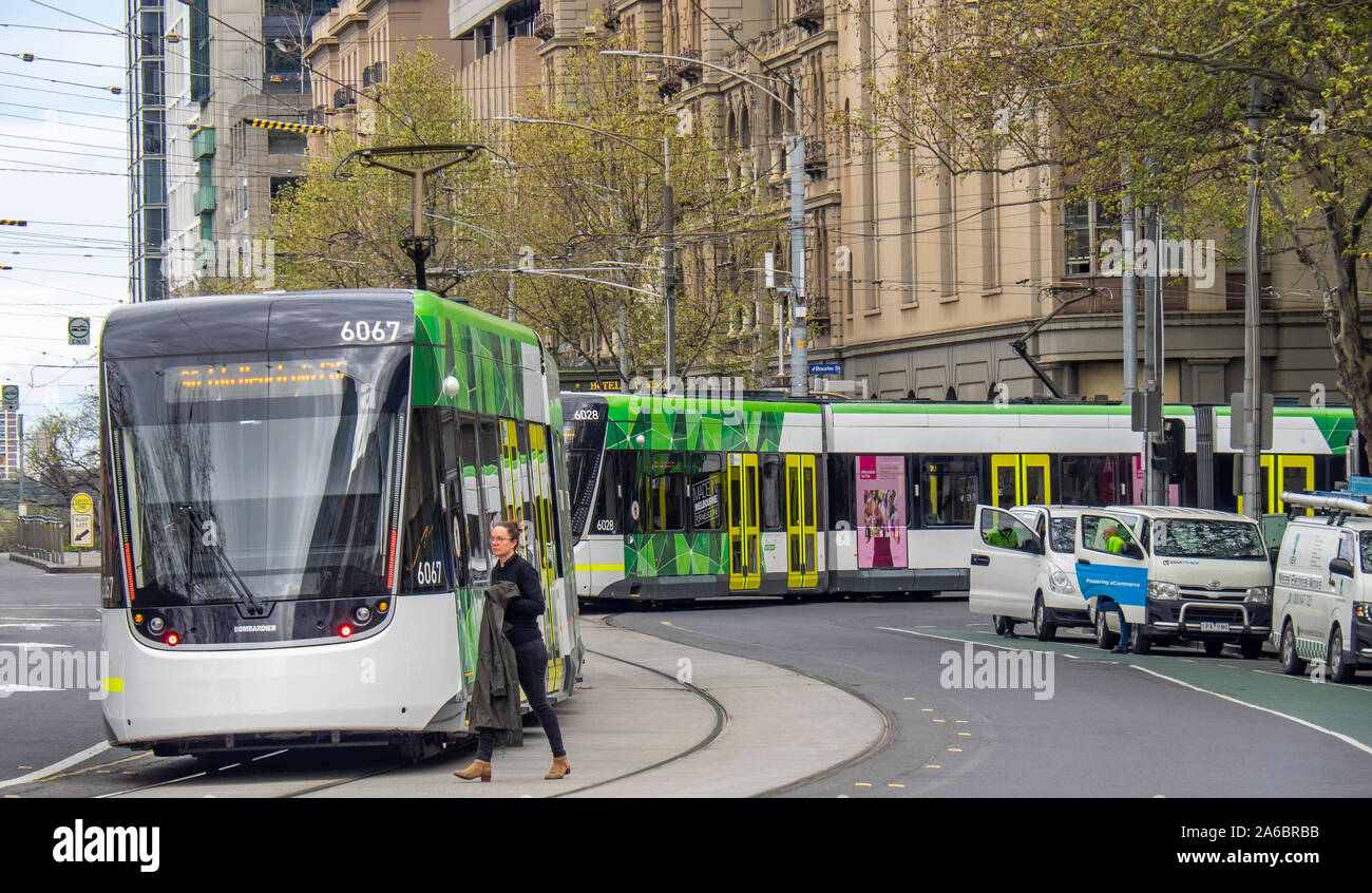 Commuter walking in front of public transport Yarra Trams tram in ...