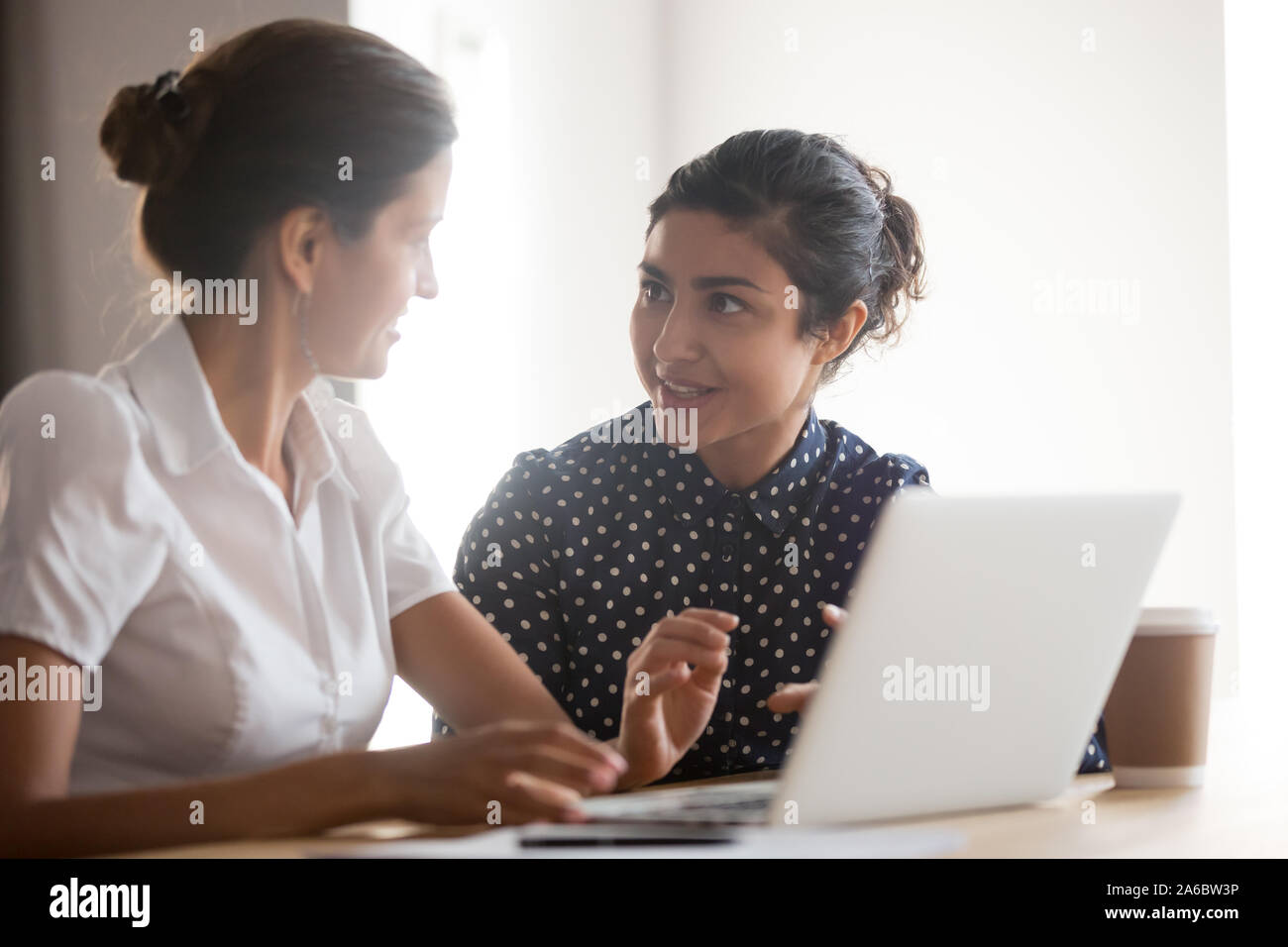 Senior female manager helping young smiling indian intern Stock Photo ...