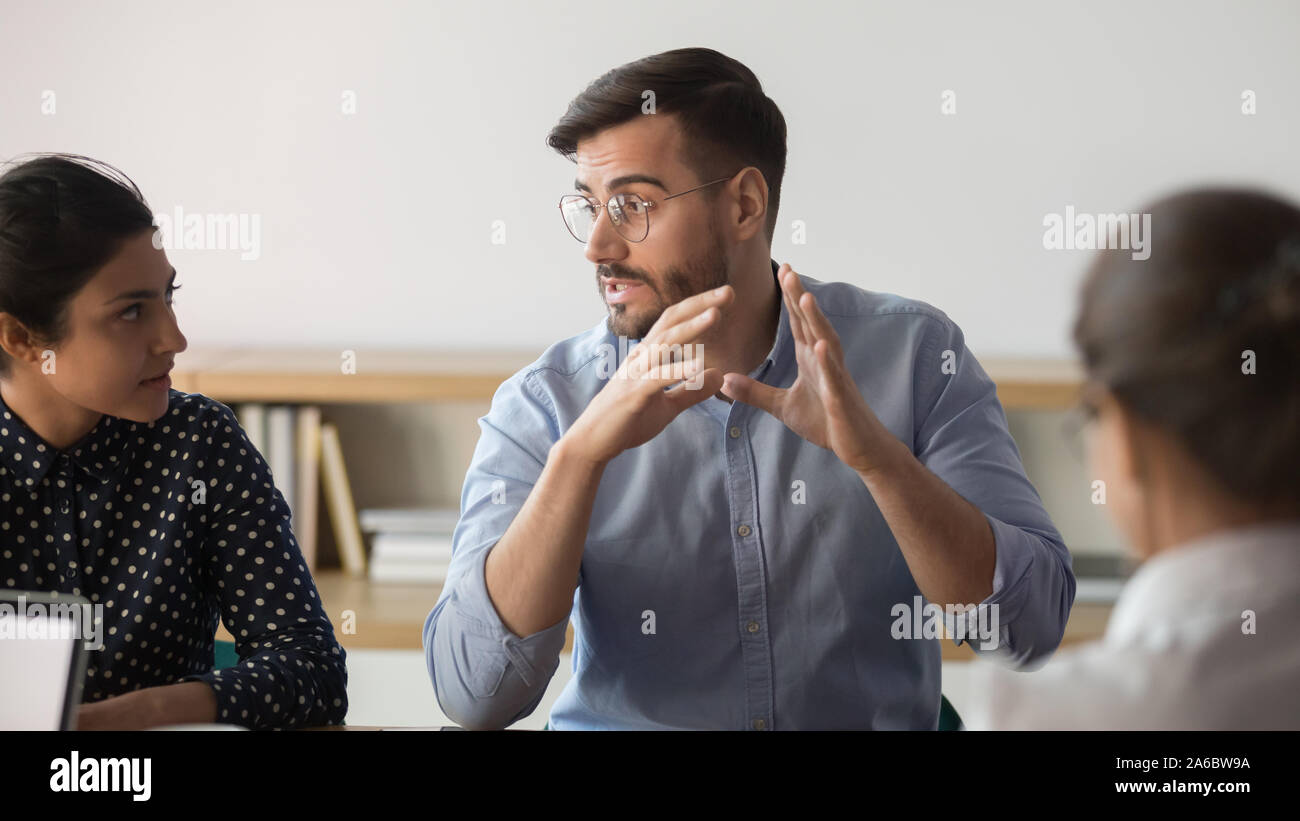Confident male boss explaining ideas to diverse team at office Stock ...