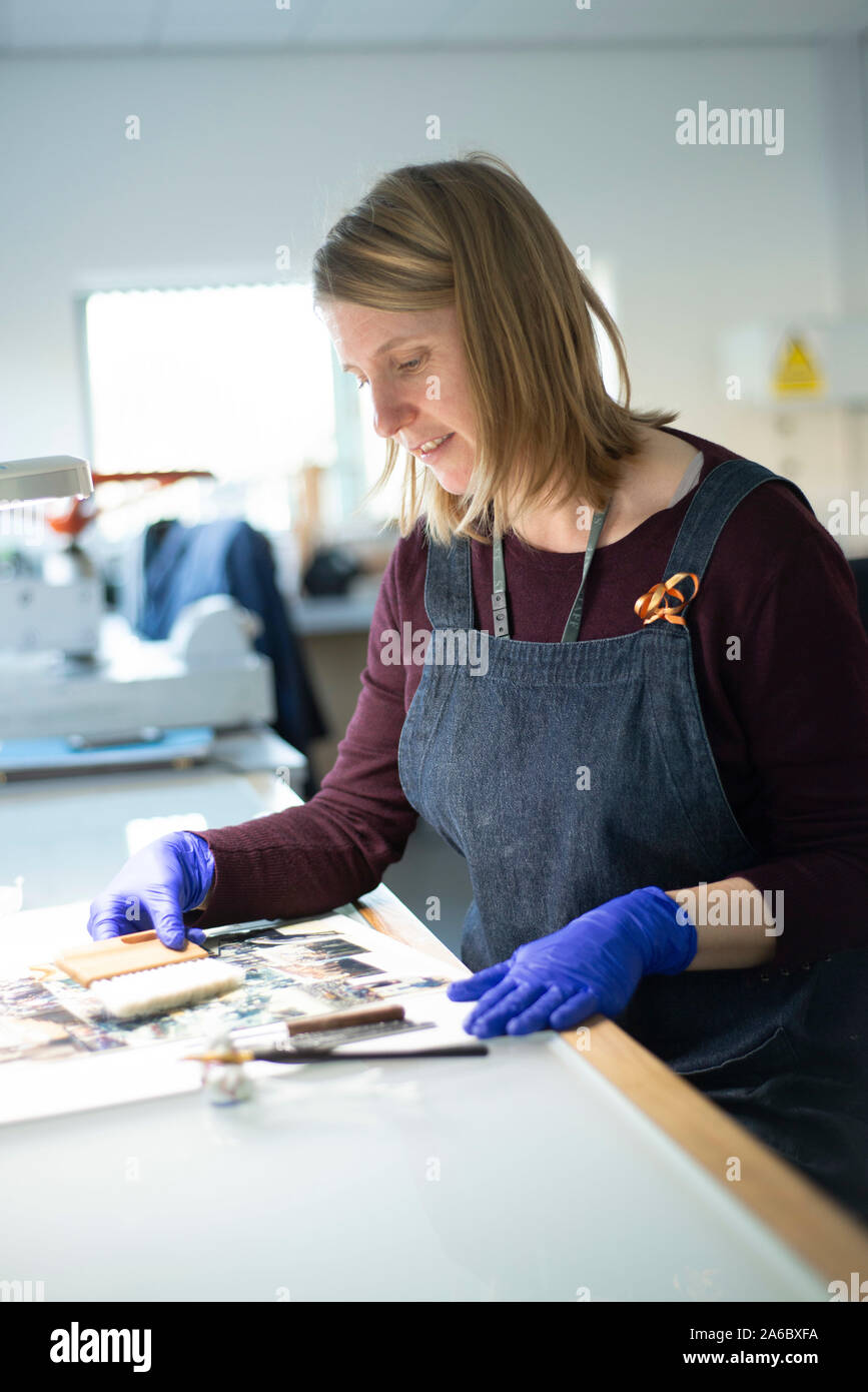 A professional conservationist works on some archive material in a lab ...