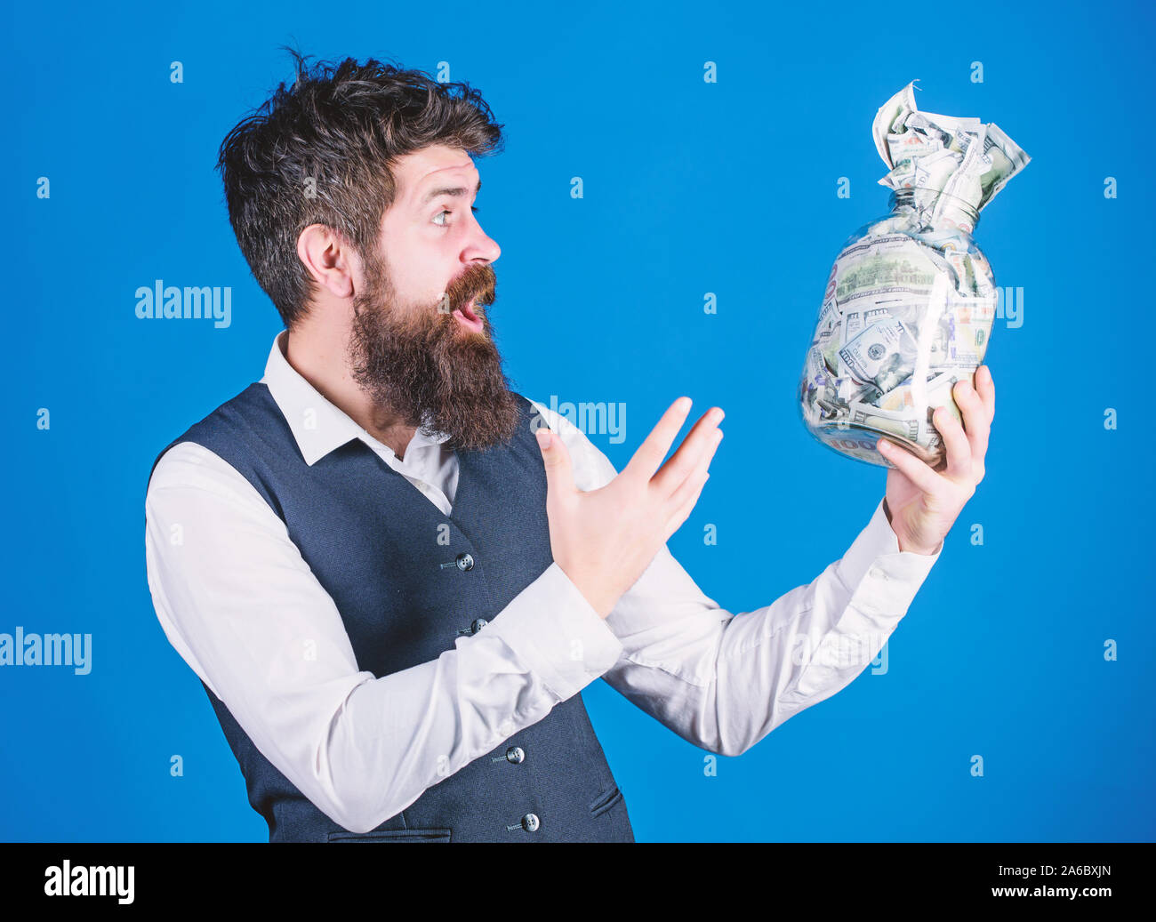 Gaining cash for his work. Excited businessman holding jar with cash ...