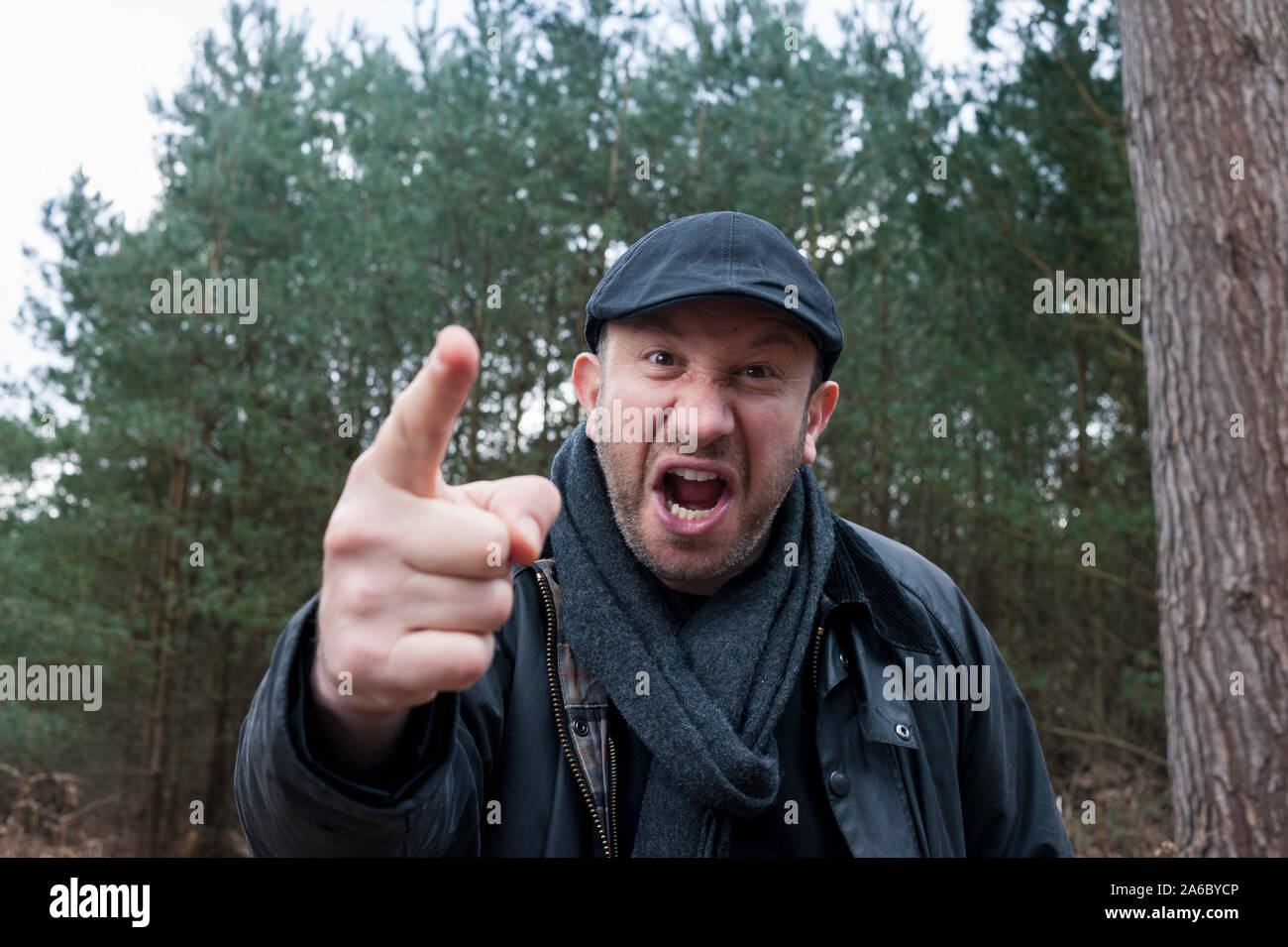 A man in a forest is angry and shouts and points Stock Photo - Alamy