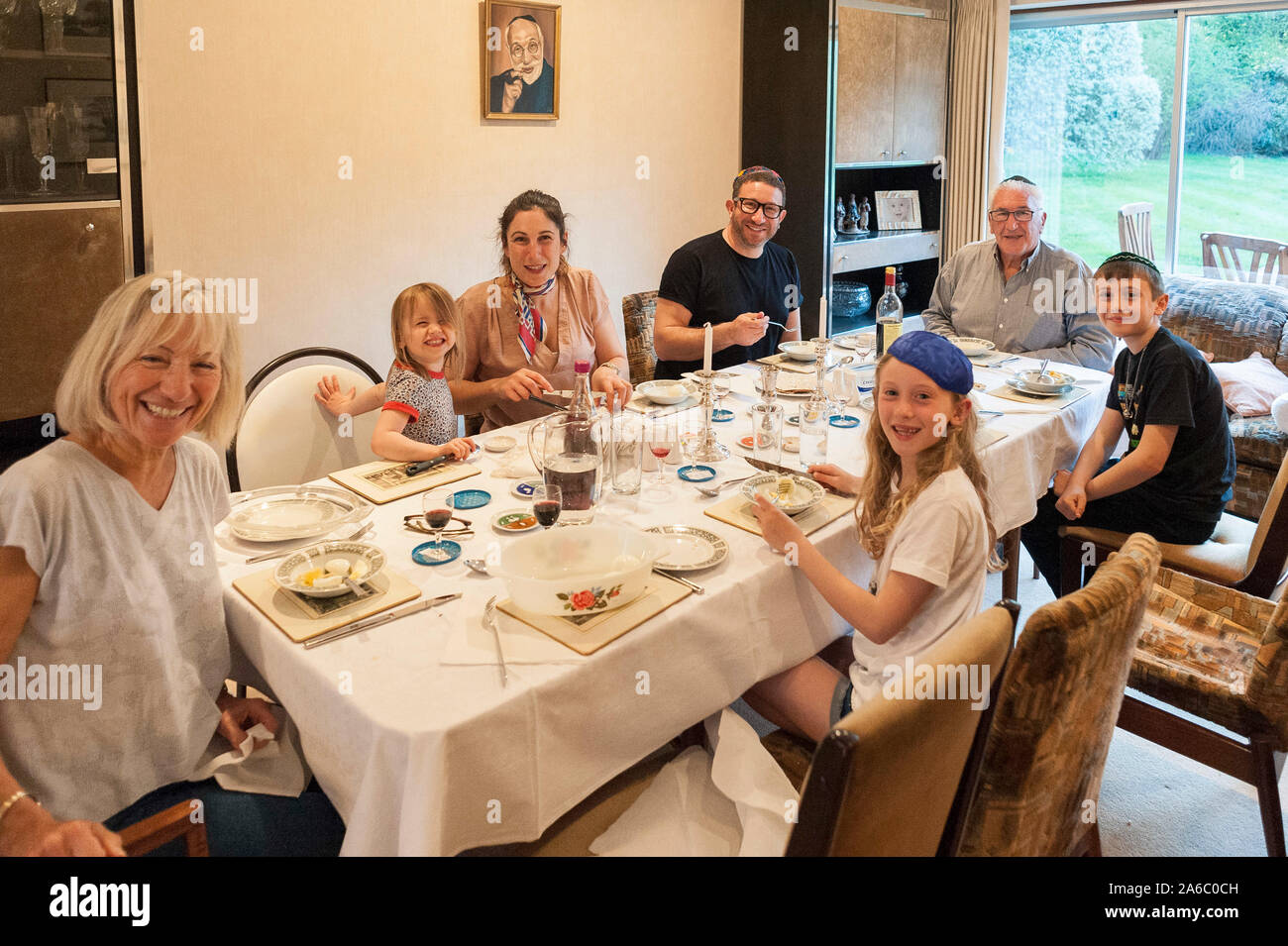 A real jewish family sit around a dining table celebrating the jewish ...