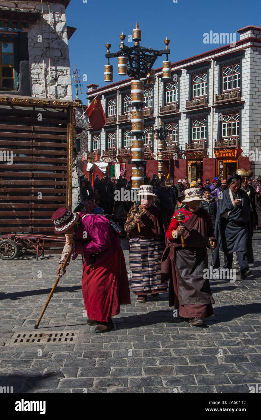 Older Tibetan women in traditional dress circumambulate the Jokhang ...