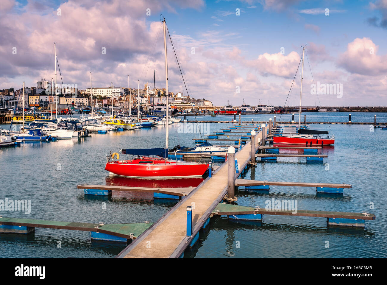 A red boat moored on a jetty in the marina of Ramsgate Royal Harbour ...