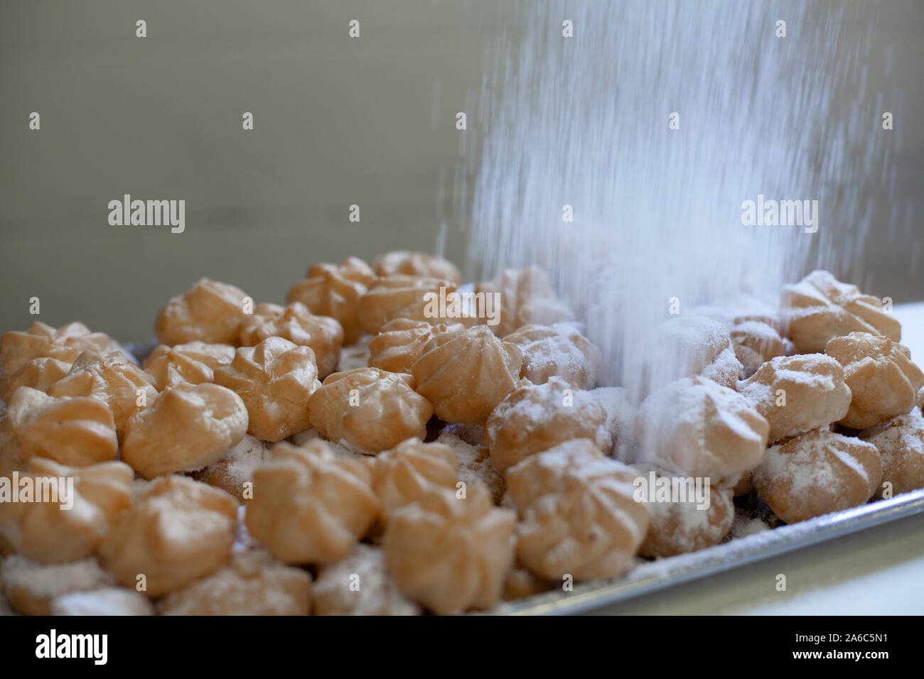 Small french choux paste cakes profitroles sifted with powdered sugar ...