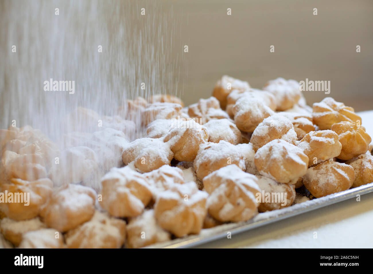 Small french choux paste cakes profitroles sifted with powdered sugar ...