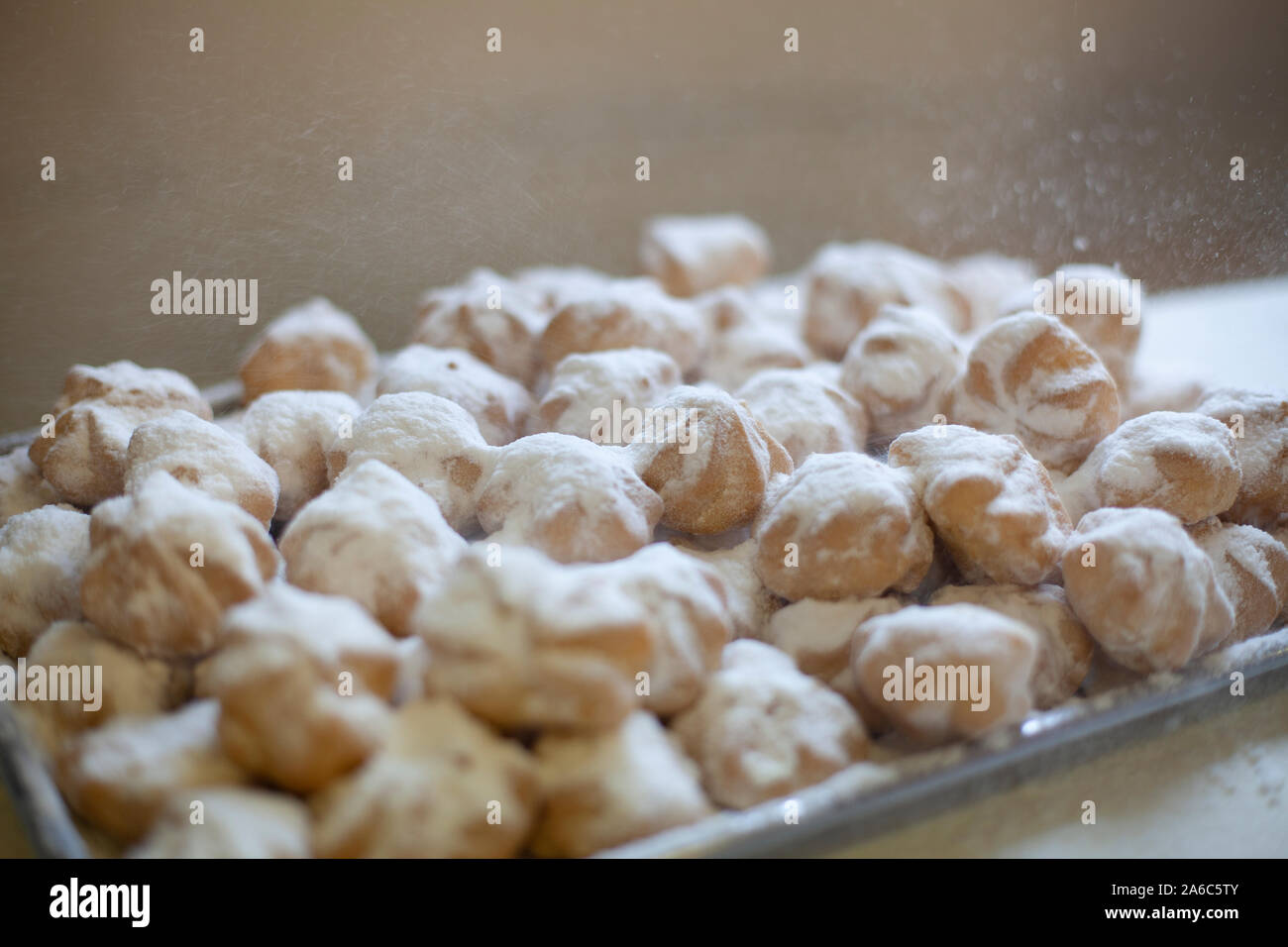 Small french choux paste cakes profitroles sifted with powdered sugar ...