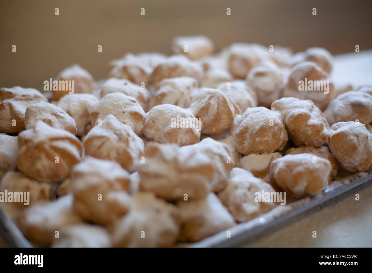 Small french choux paste cakes profitroles sifted with powdered sugar ...