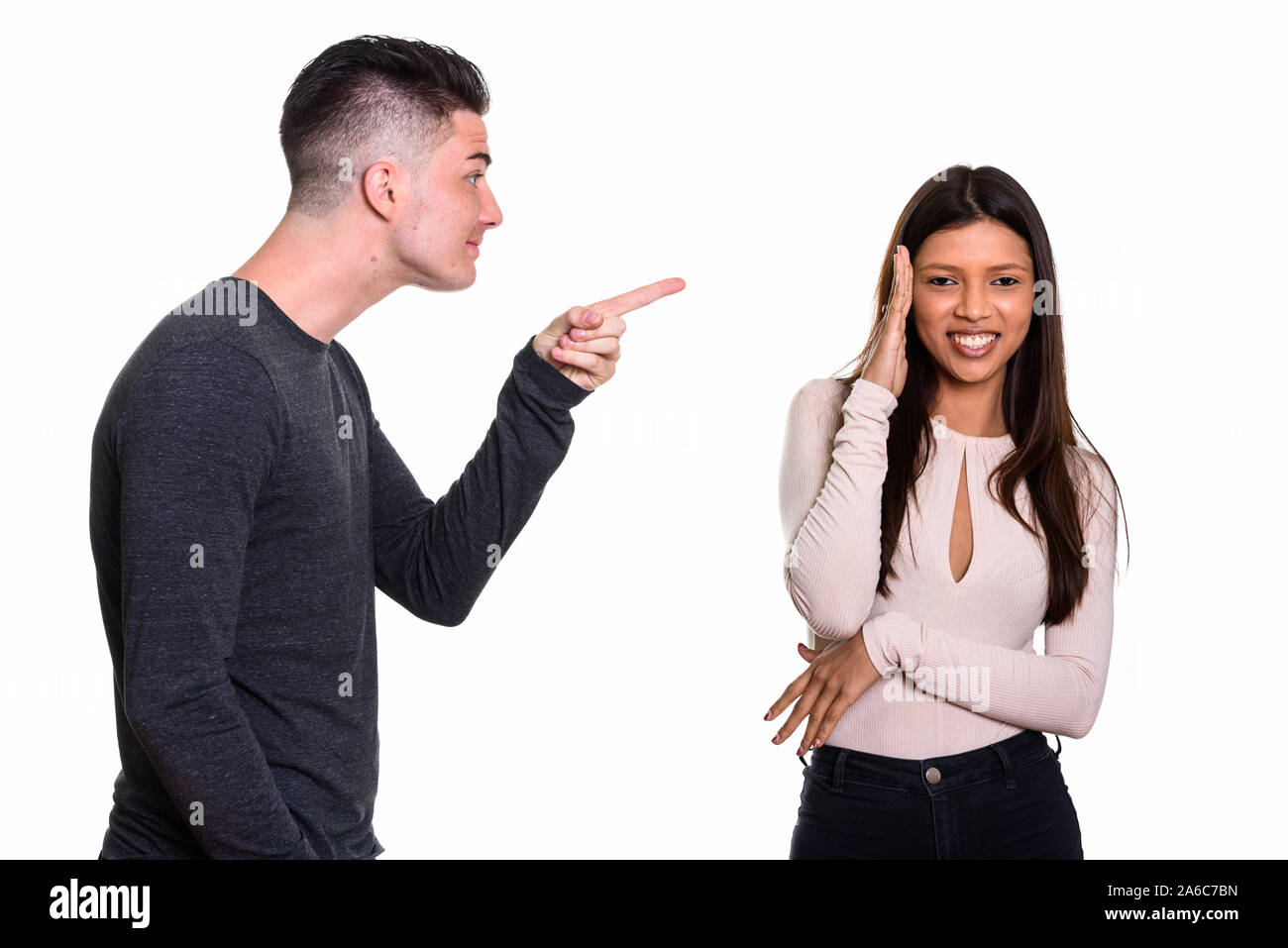 Studio shot of young couple with man pointing finger and woman l Stock ...