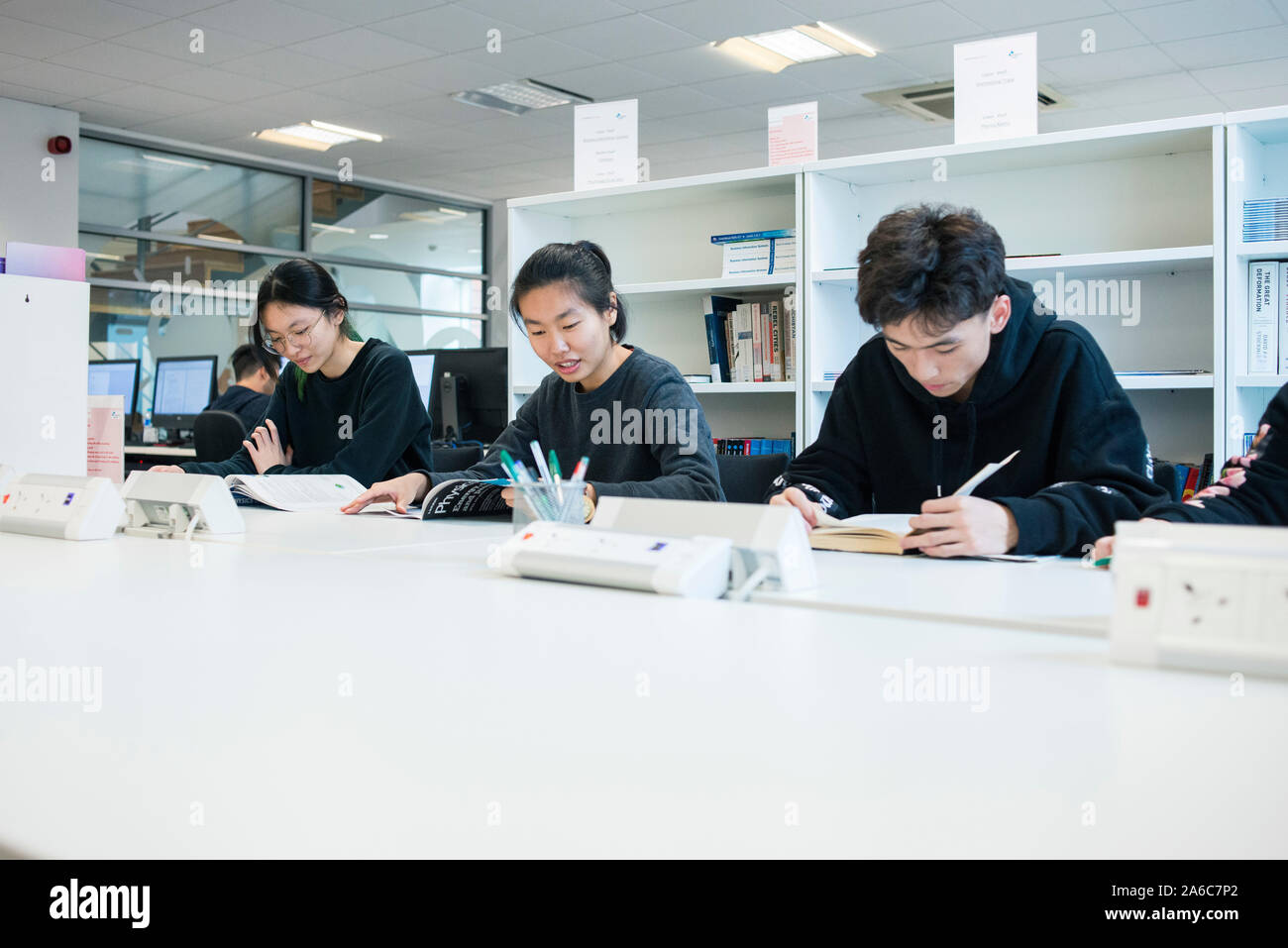 International overseas students sitting in a University library reading ...