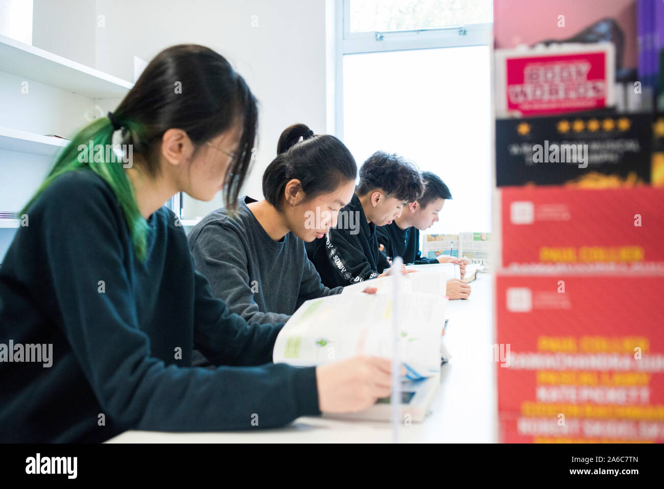 International overseas students sitting in a University library reading ...