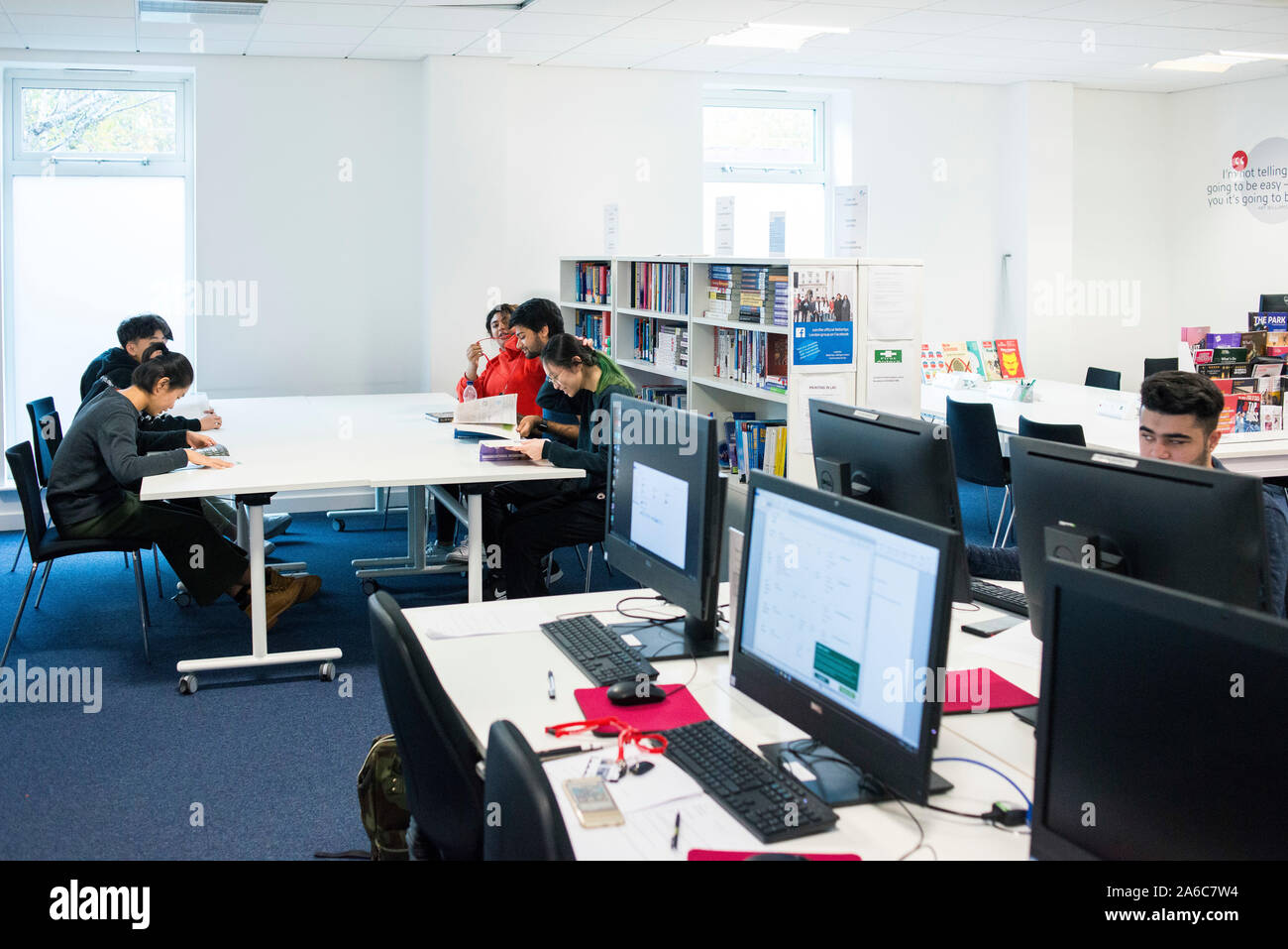 International overseas students sitting in a University library reading ...