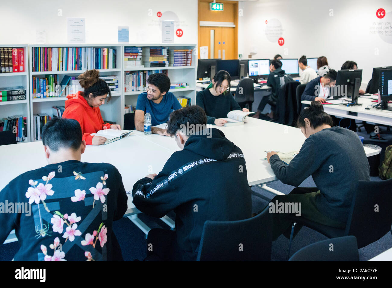 International overseas students sitting in a University library reading ...