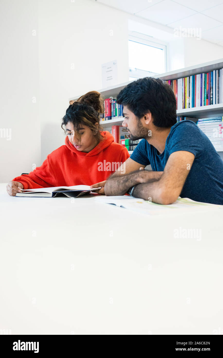 International overseas students sitting in a University library reading ...