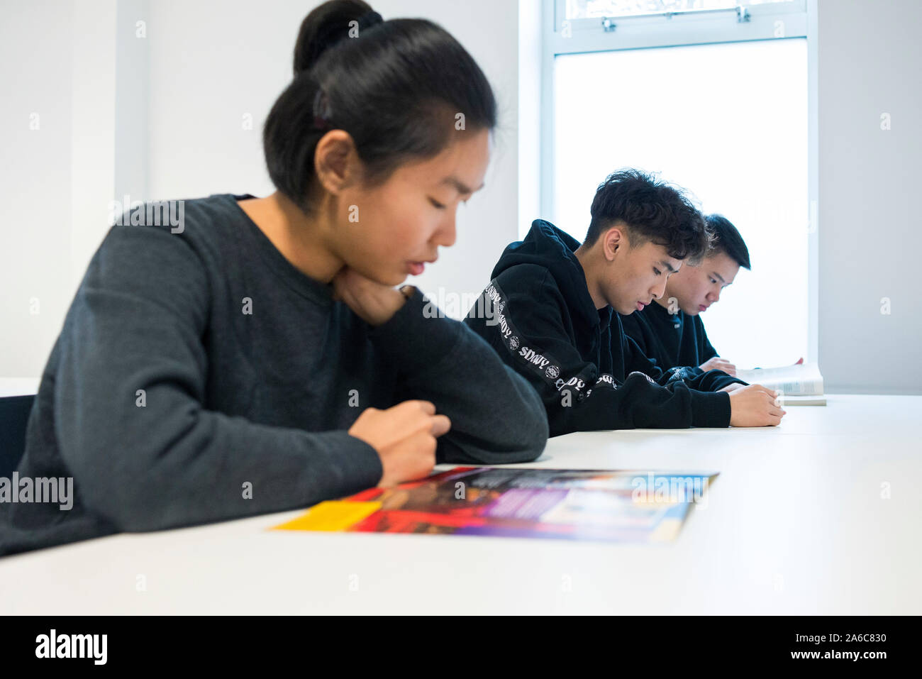 International overseas students sitting in a University library reading ...