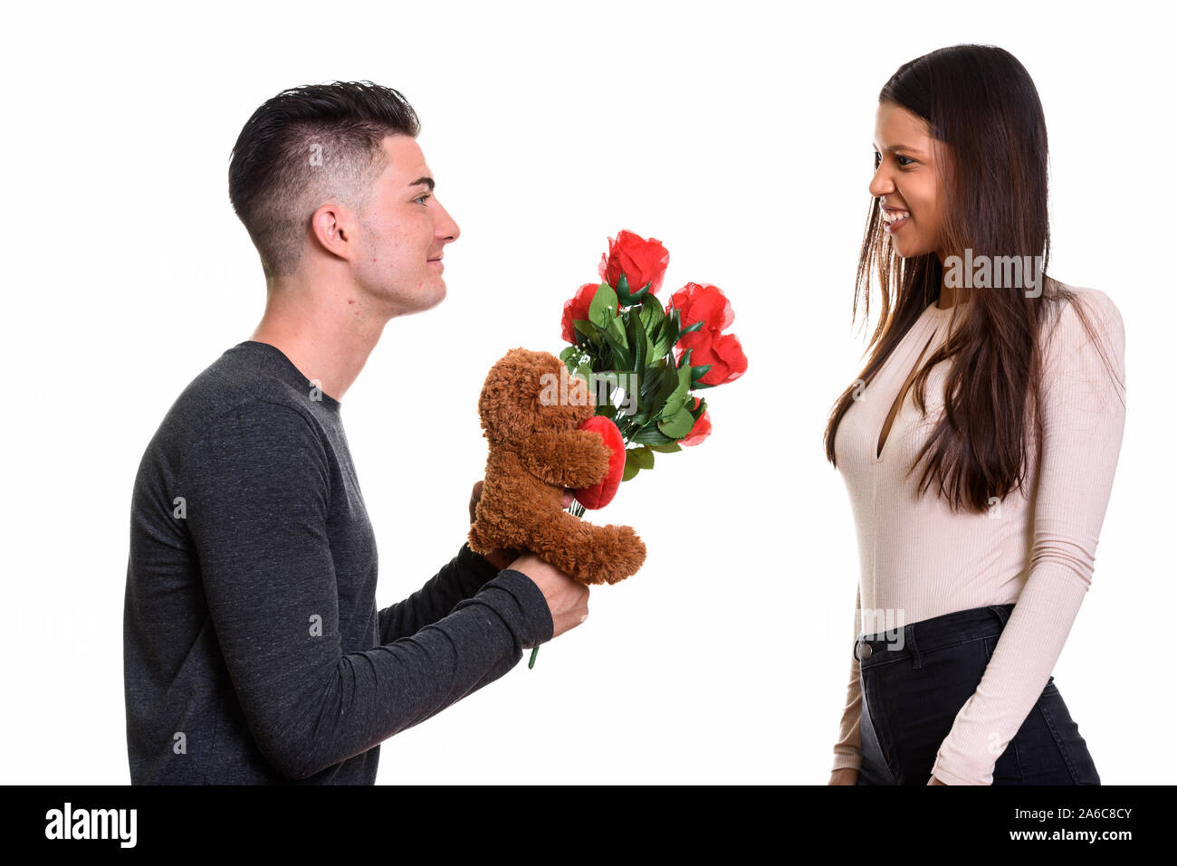 Young happy couple smiling and in love with man giving red roses Stock ...